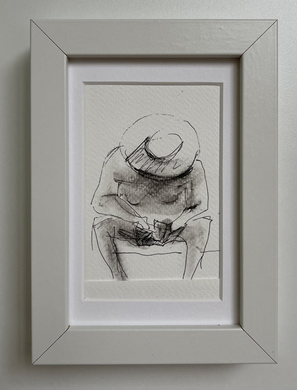 A man in a hat on the beach is busy with the phone | helloart